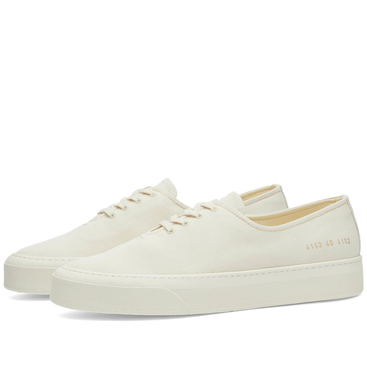 Woman by Common Projects Women's Four Hole Canvas Sneakers in Off White ...